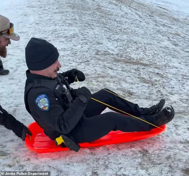 Moment cop crashes into young child during sledding day out