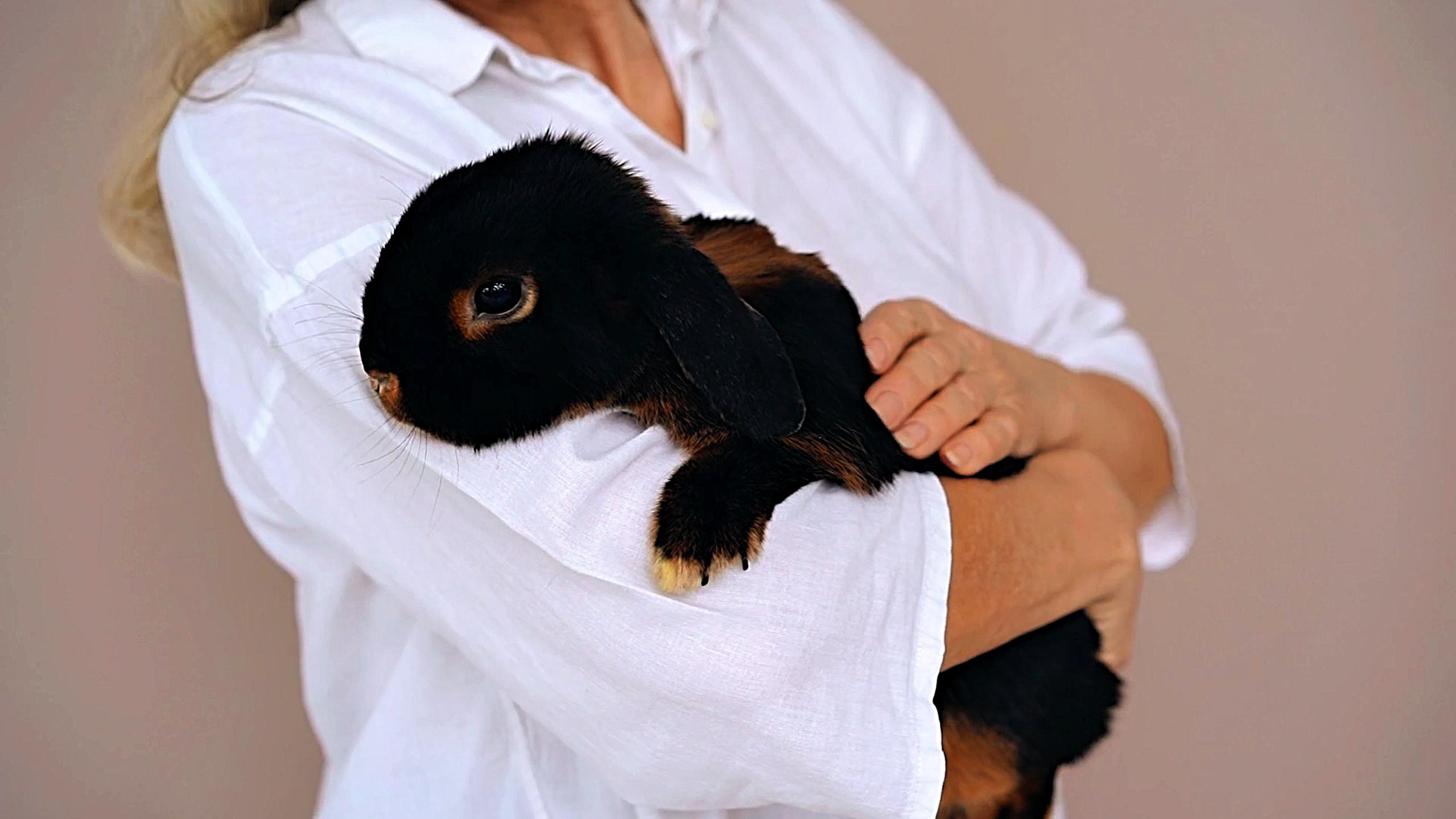 A woman shows affection to a rabbit in a peaceful moment