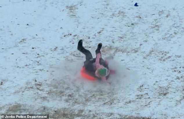 Moment cop crashes into young child during sledding day out
