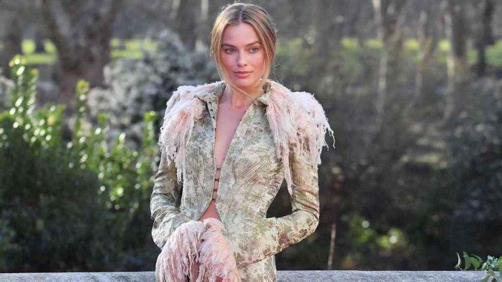 Margot Robbie wears miniskirt & sheer tights under bold John Galliano coat