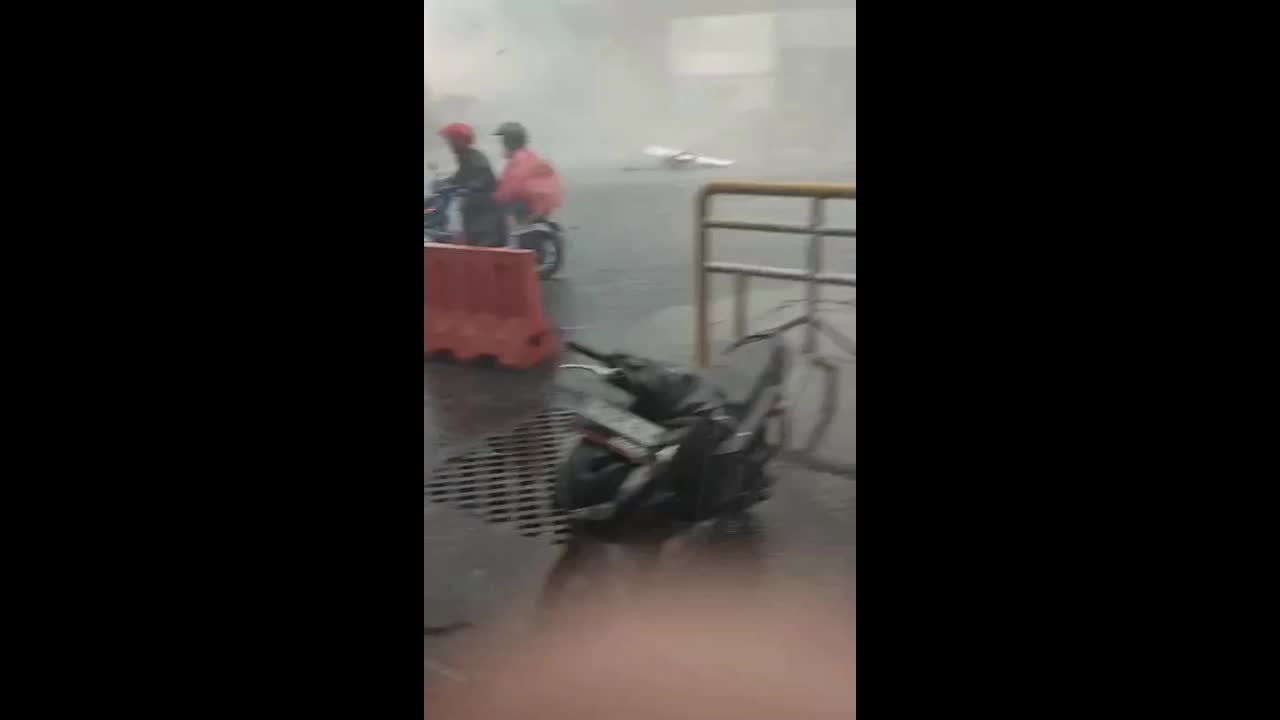 Motorcycle rider battles storm as it over signs and tears down branches