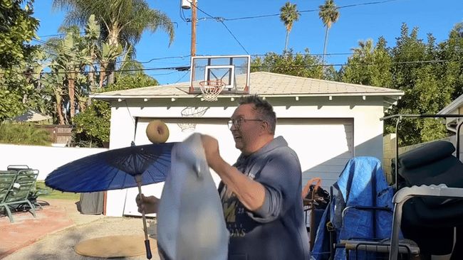 Juggler sinks Nicolas Cage pillow shot while rolling donut on parasol
