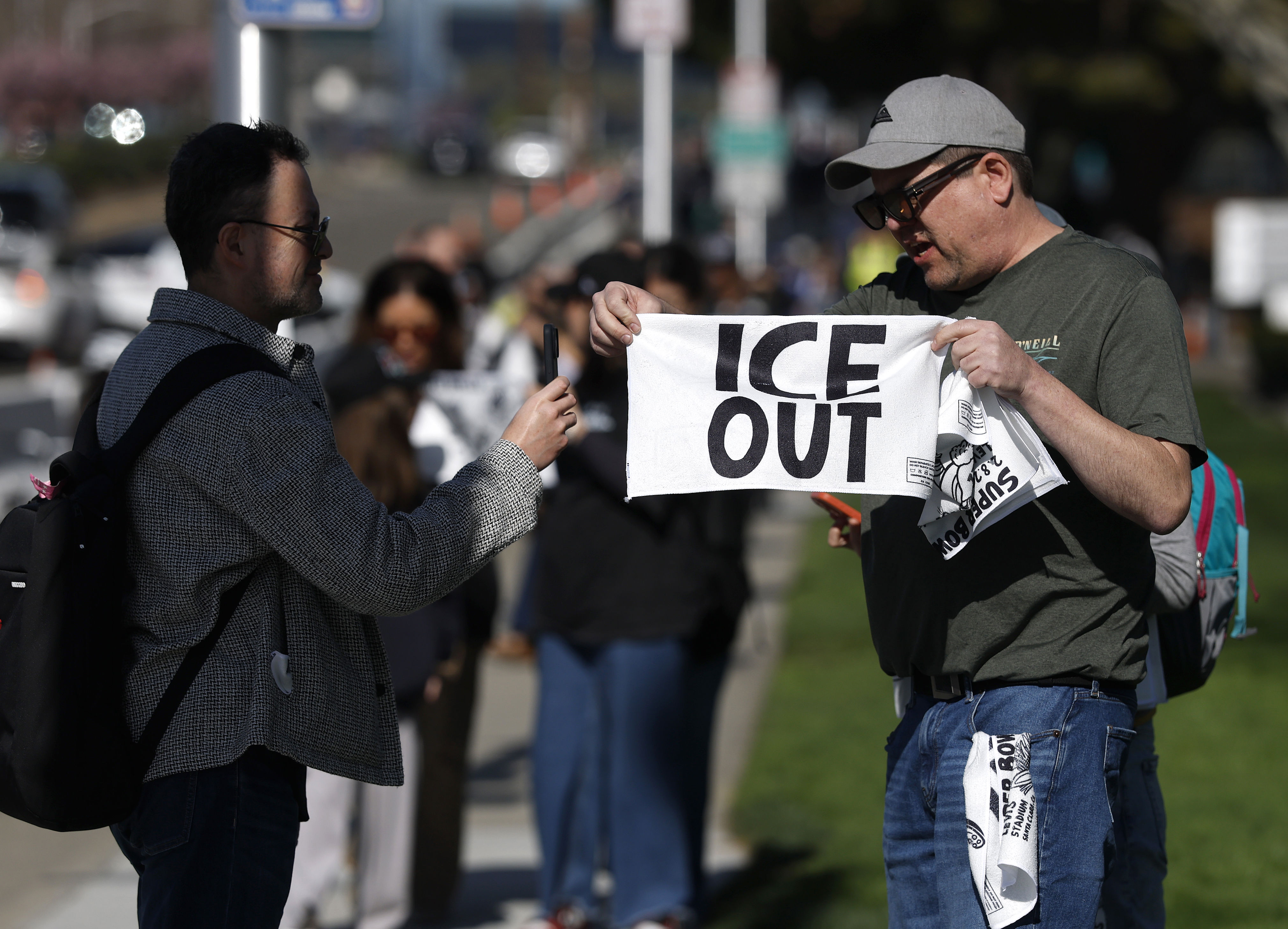 Activists hand out 'Ice Out' towels at Super Bowl LX