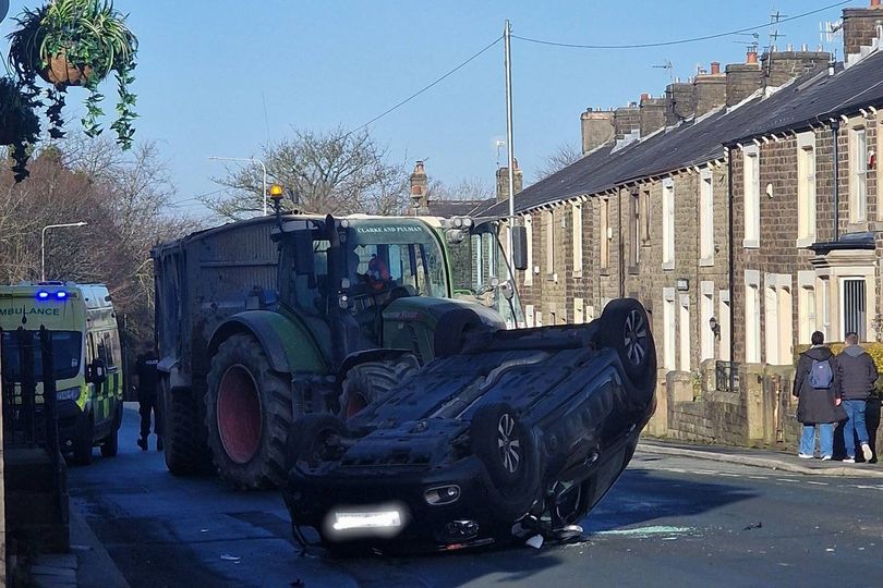 Car lands on its roof after dramatic crash on busy main road