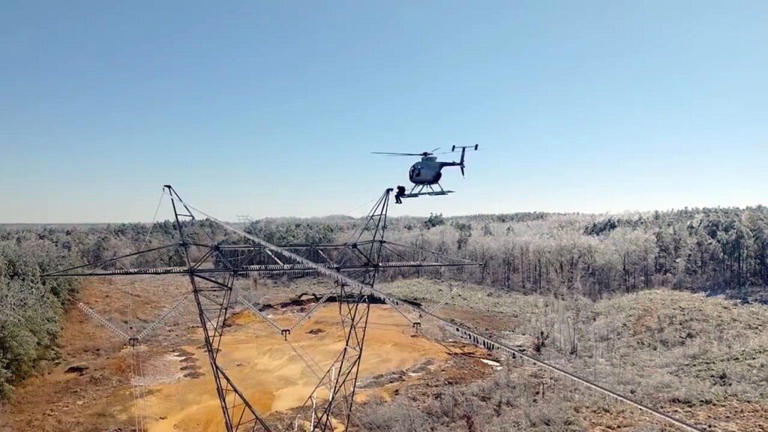 Helicopter crew inspect power lines after deadly US storm