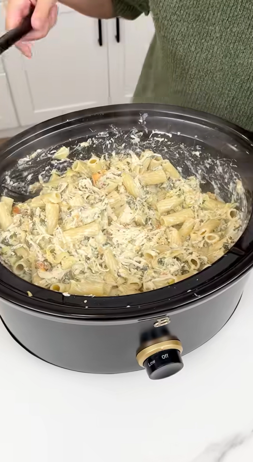Making creamy artichoke spinach chicken pasta everyone loves