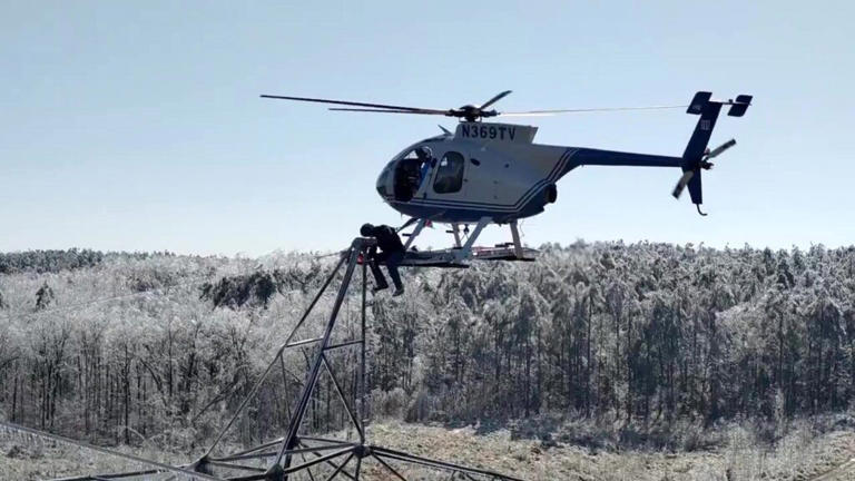 Helicopter crew inspect power lines after deadly US storm