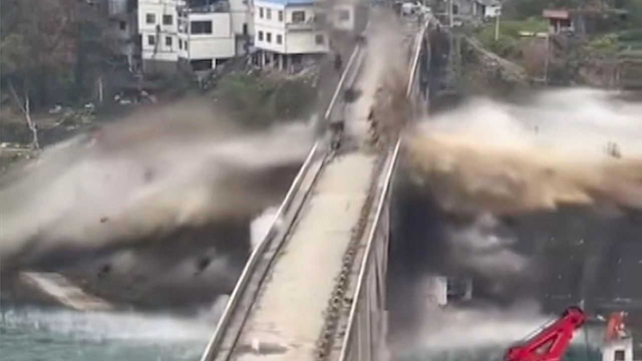 Explosive demolition sends bridge crashing into river