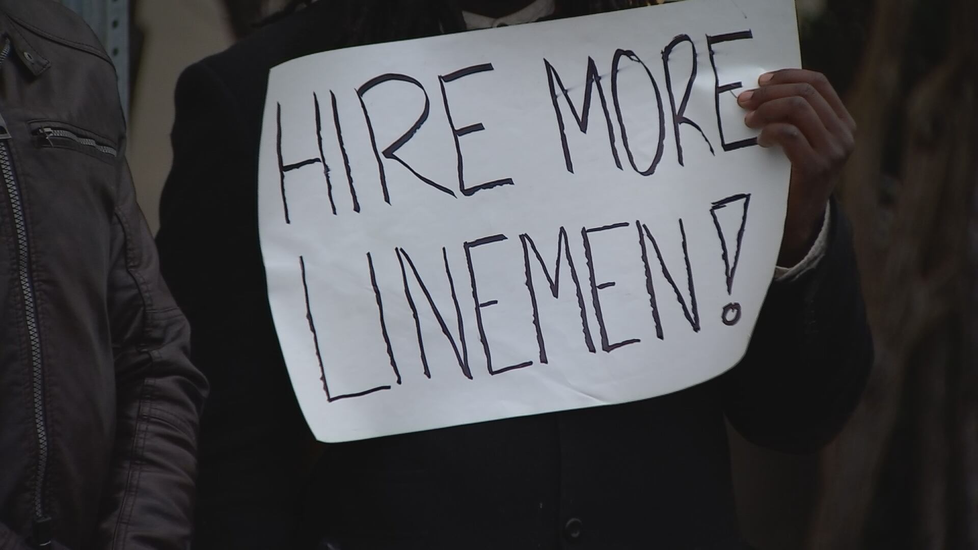 Protesters going on a week without power gather outside NES headquarters