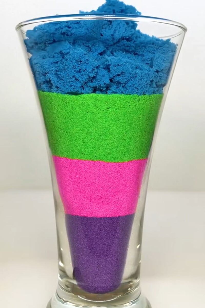 Layered kinetic sand in glass vase