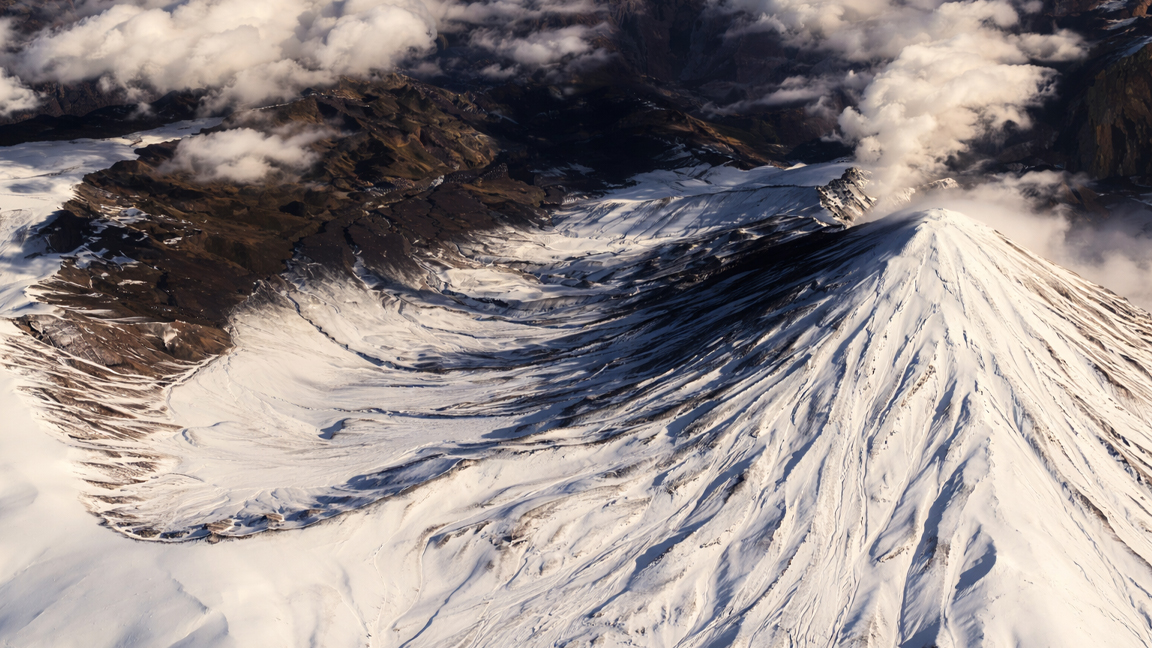 Cima nevada entre las nubes