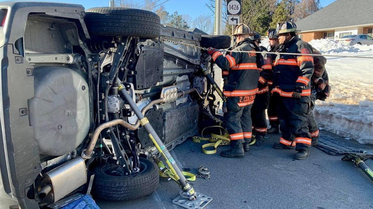 Firefighters rescue person trapped in car during rollover crash