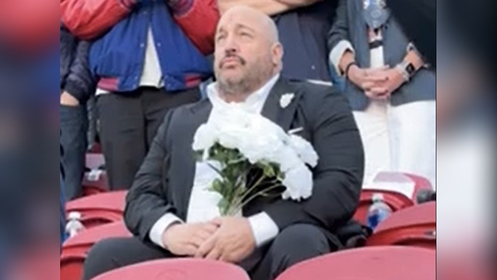 Kevin James sad and alone with a bouquet of flowers at the Super Bowl