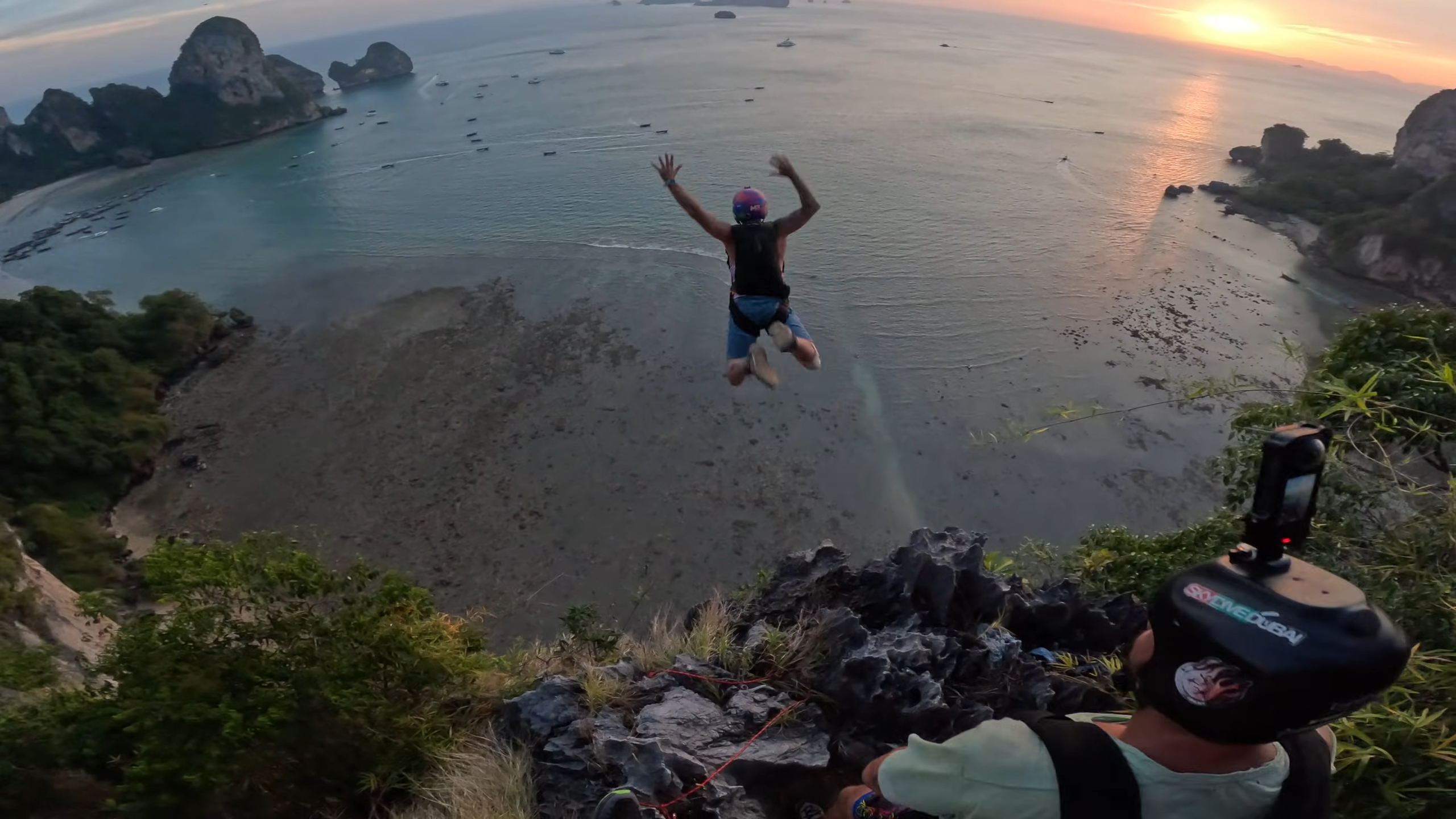 Man jumps from a huge cliff into shallow water