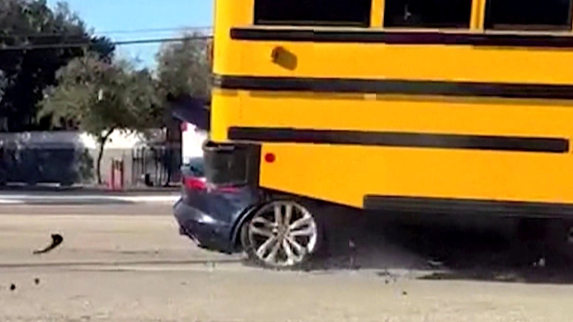 Video: Sports car drives directly underneath a school bus