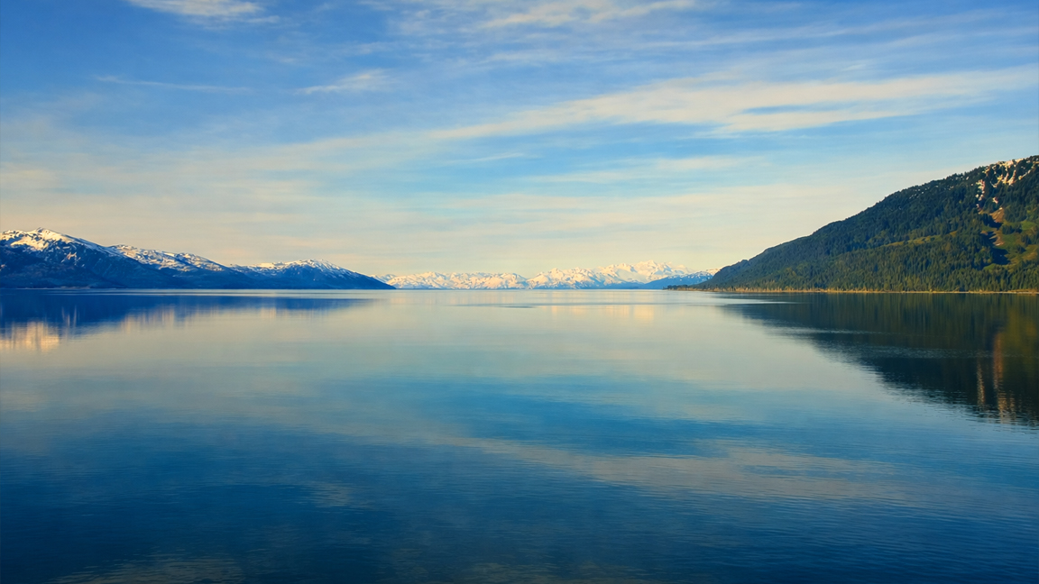 Lago tranquillo con montagne innevate