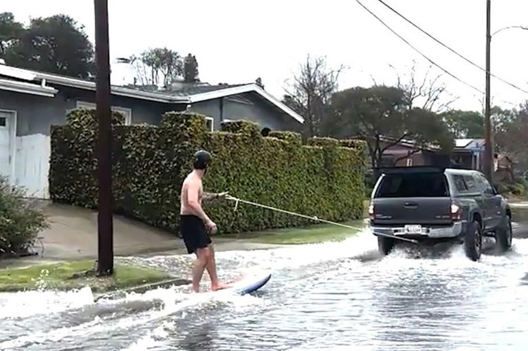 Surfer shreds waves on SoCal street during wild flooding: video
