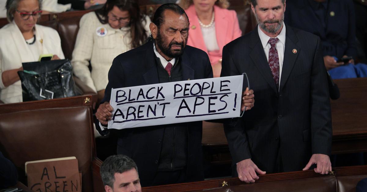 Rep Al Green escorted from House chambers after holding up sign reading ...