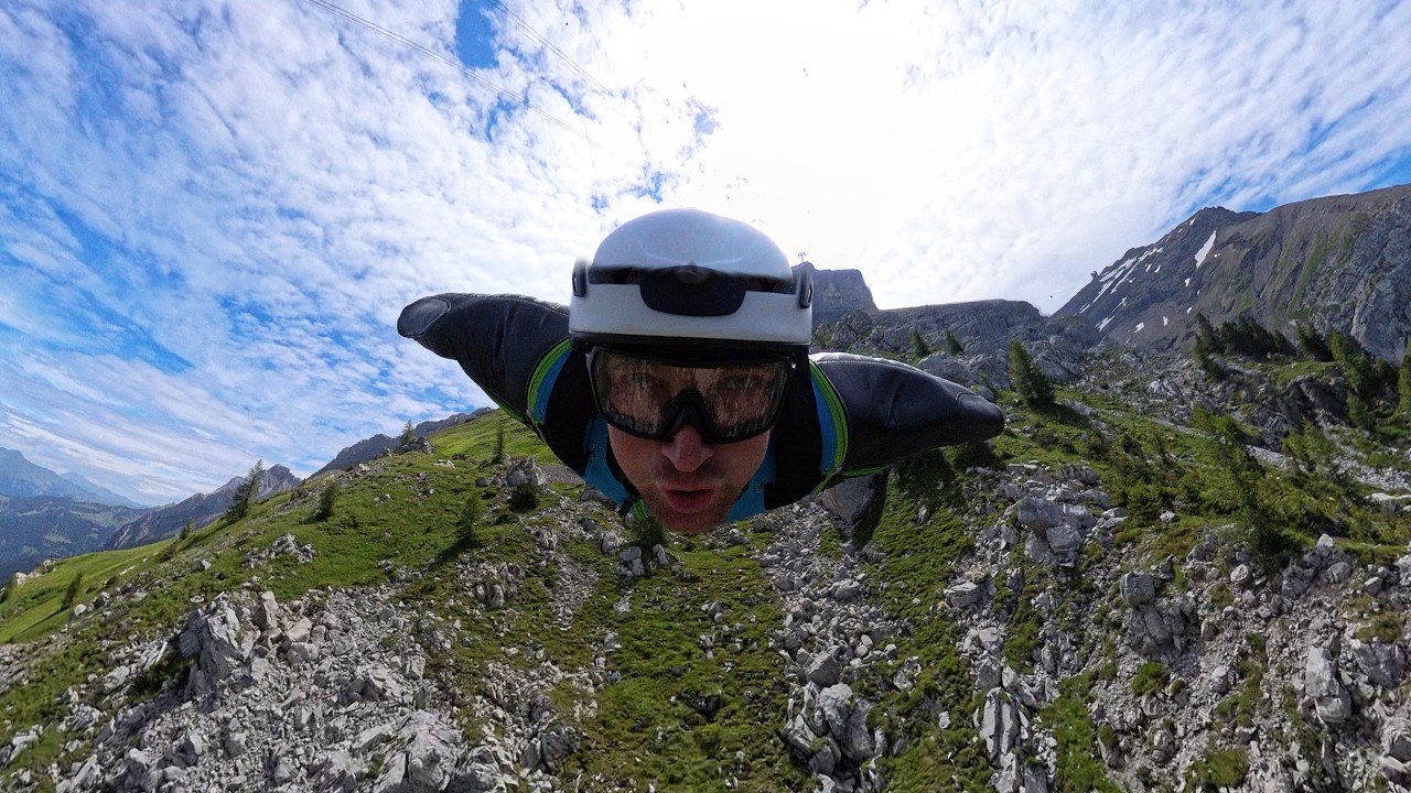 Man jumps from a cliff into a mountain waterfall
