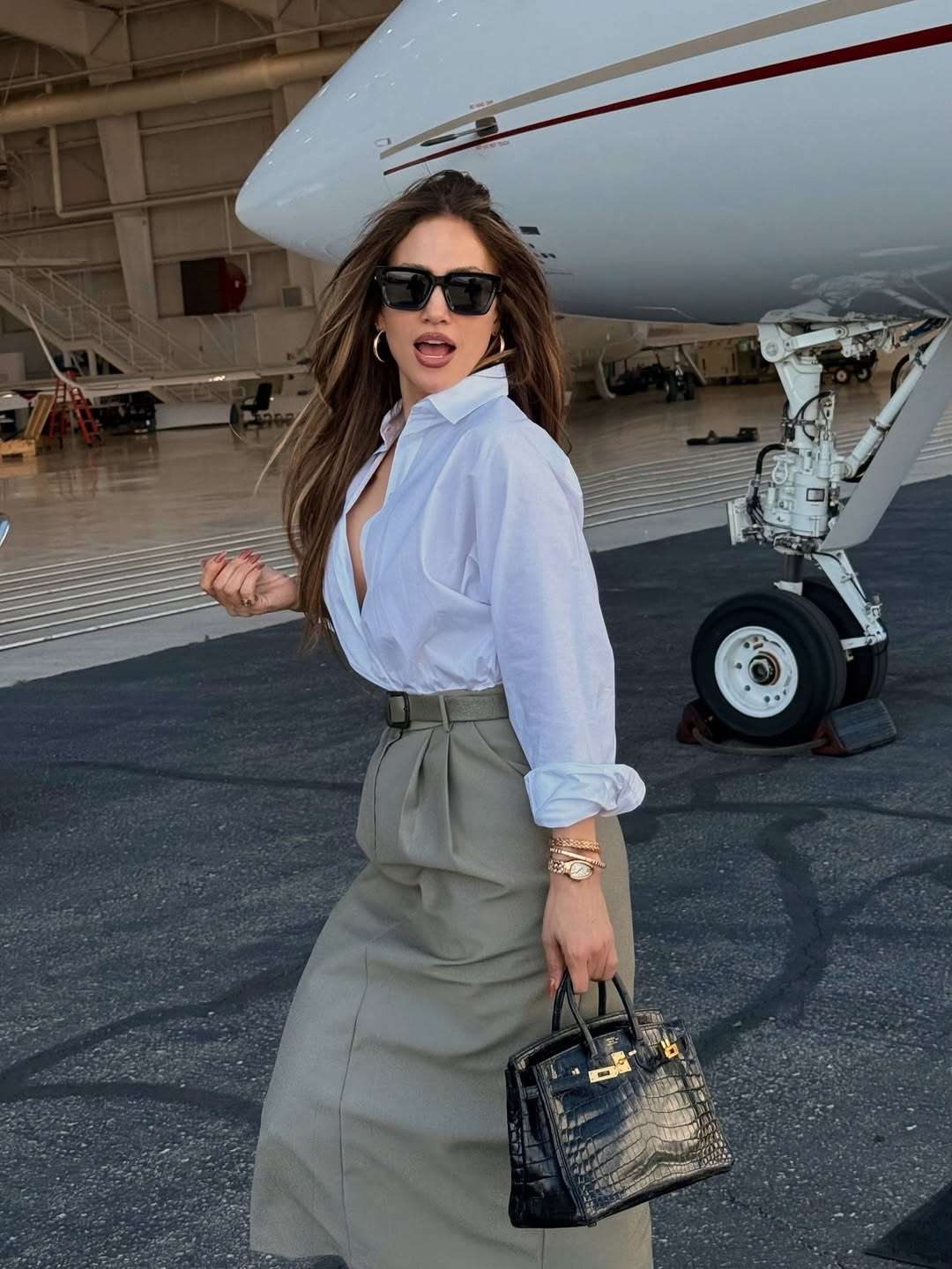 Jennifer Lopez's airport look includes a plunging button-up and an ...