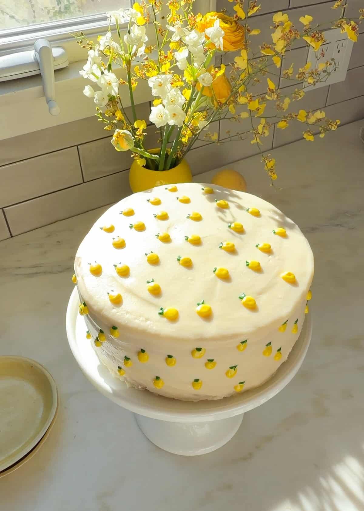 Assembling the lemon cake with delicious frosting and little lemons on top