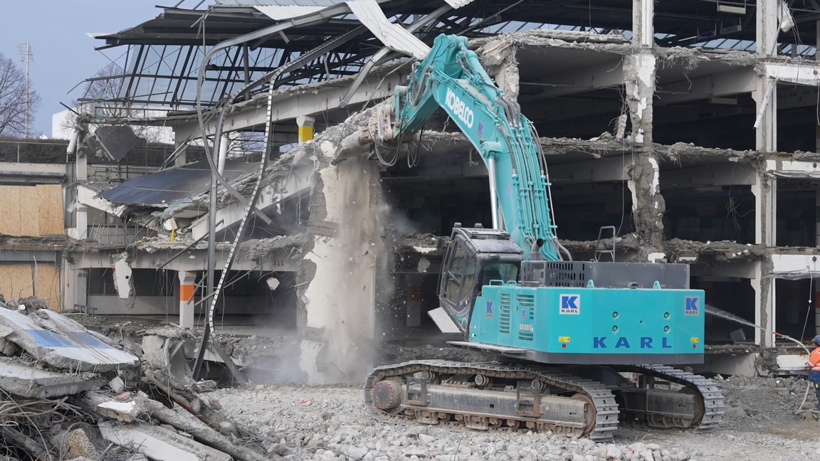 Huge excavator tearing down concrete structure