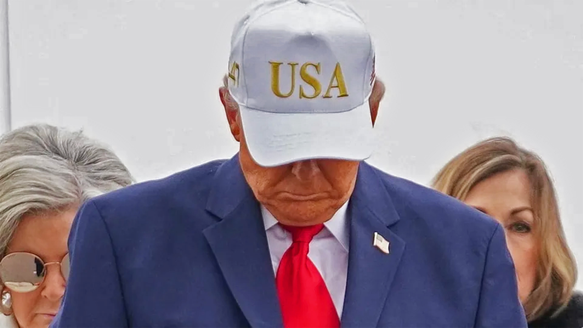 Trump wears a baseball hat as fallen soldiers arrive