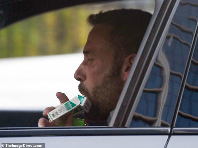 Ben Affleck pulls cigarette out of its box with his mouth while driving