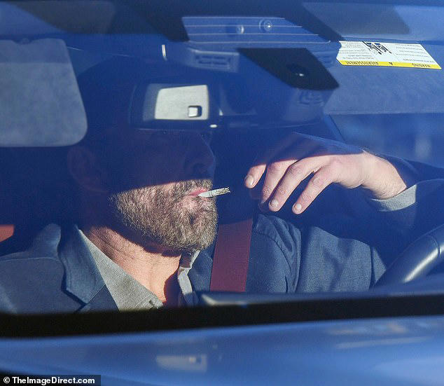 Ben Affleck pulls cigarette out of its box with his mouth while driving