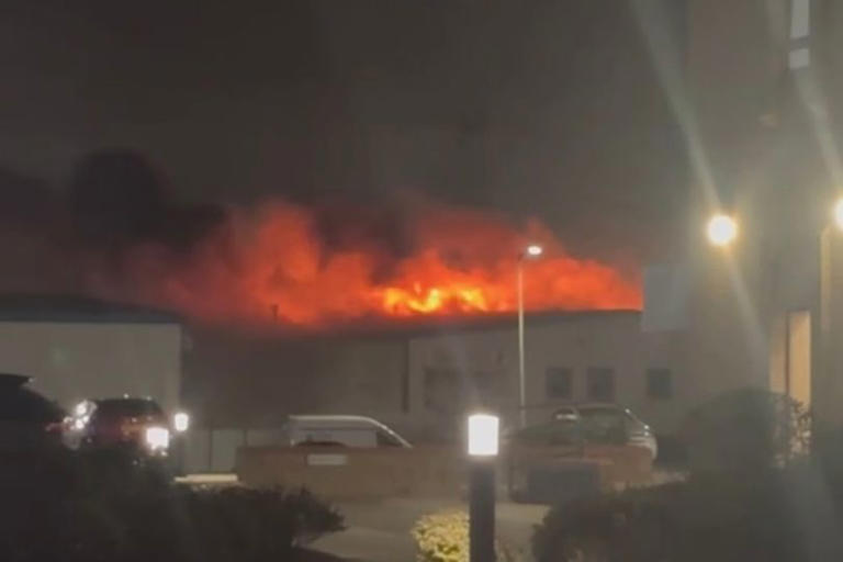 Huge fire breaks out in warehouse with 'thick black smoke spreading ...