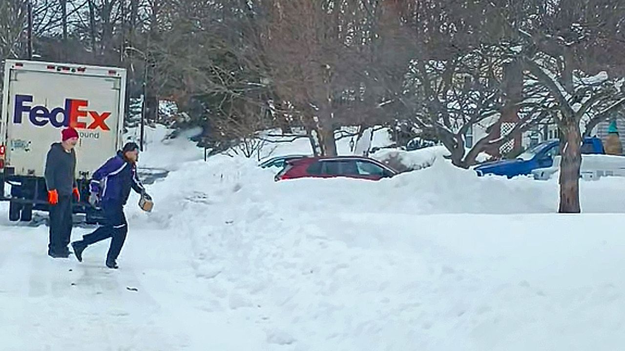 Incredibly committed FedEx driver sprints into snow-covered yard for ...