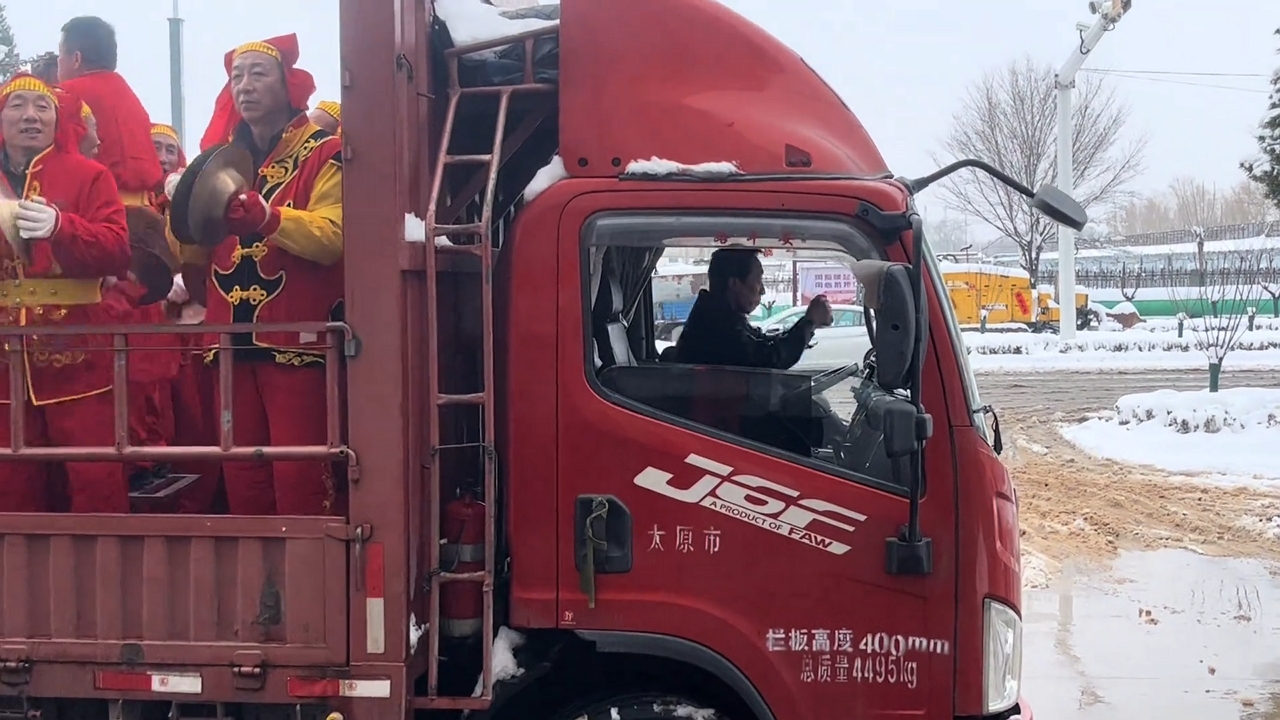 Passengers play cymbals as driver dances in Shanxi, China