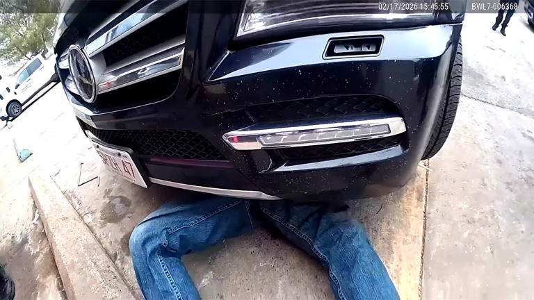 Police arrive to find driver pinned under Mercedes SUV