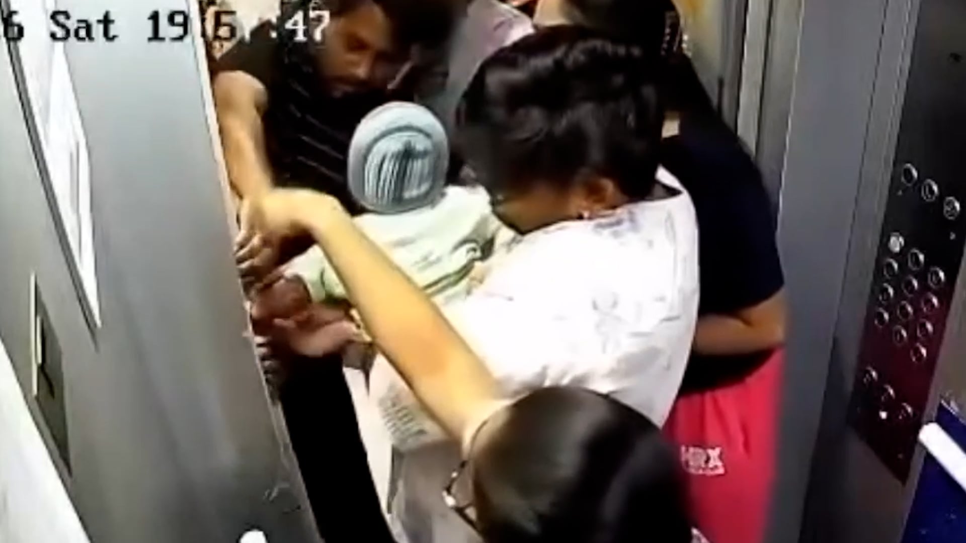 CCTV shows scary moment residents panic to free baby's hand from lift door