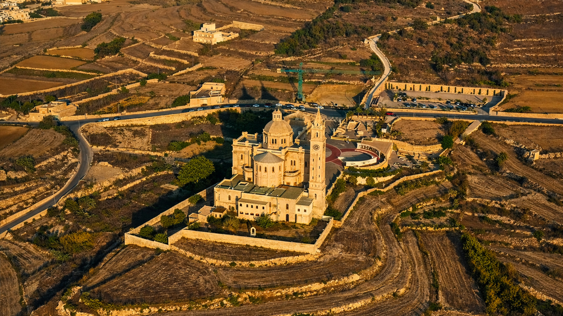 Imponente basílica en la cima domina el tranquilo paisaje rural