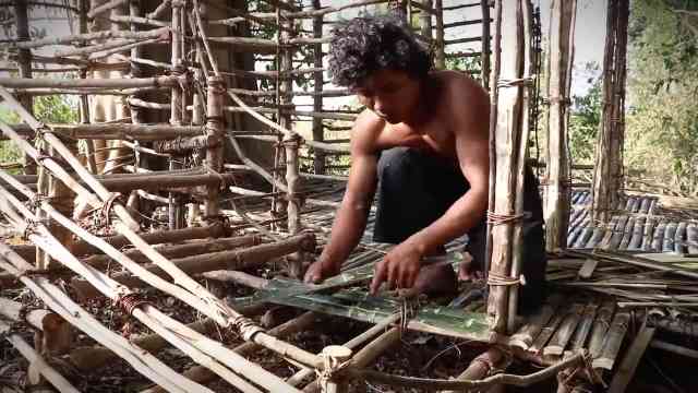 Watch these primitive men craft a mud house with a slide into a dark pool
