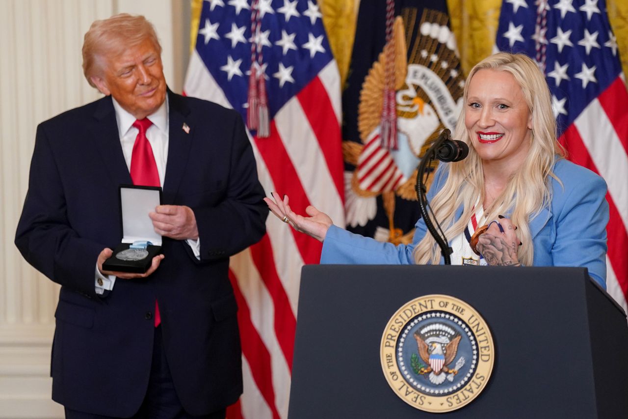Olympian Kaillie Humphries cries as she gives her medal to Trump