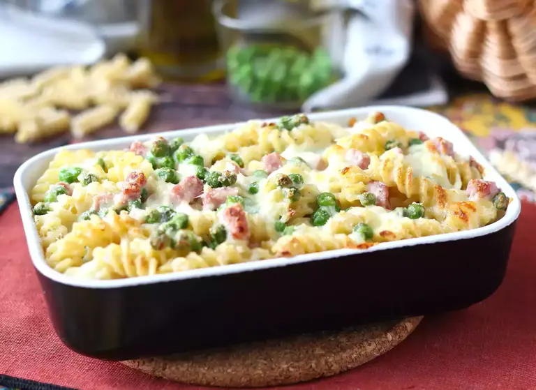 Romig gebakken pasta met erwten en gegratineerde ham