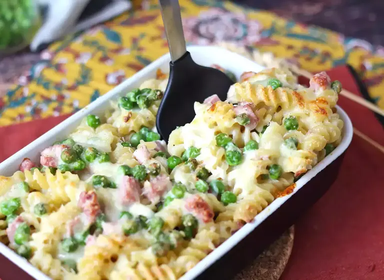 Romig gebakken pasta met erwten en gegratineerde ham