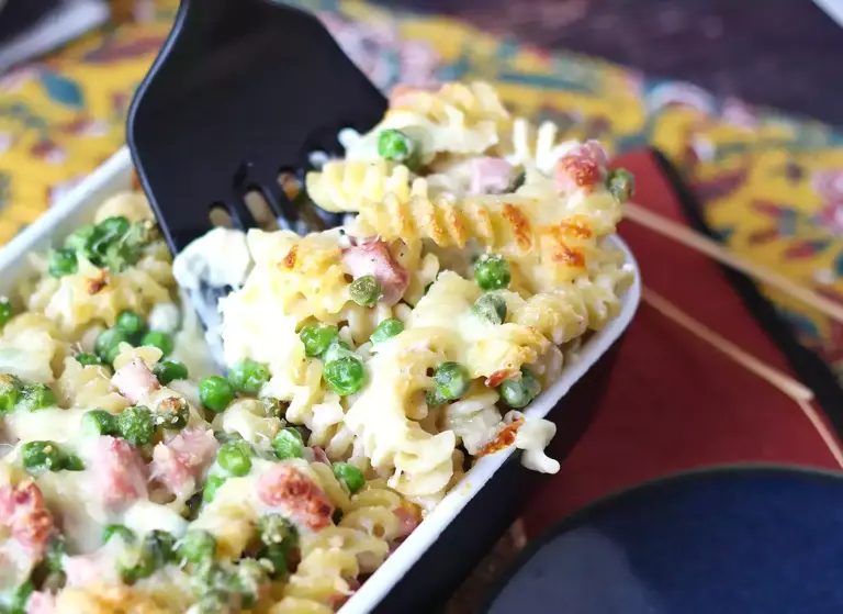 Romig gebakken pasta met erwten en gegratineerde ham