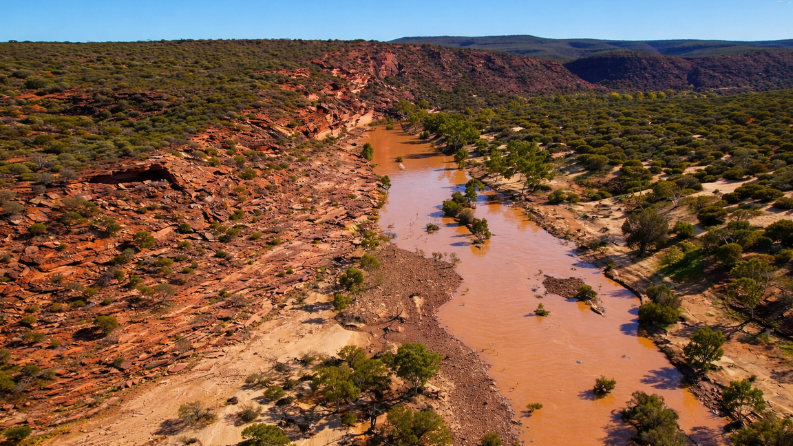 Rust colored river winding through a rugged desert valley