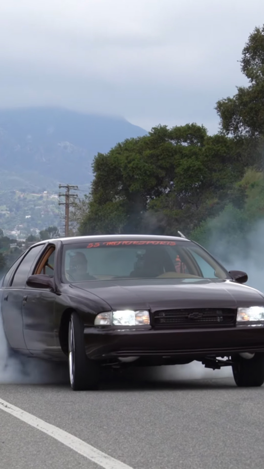 Classic Chevy Impala wild burnout moment on open road