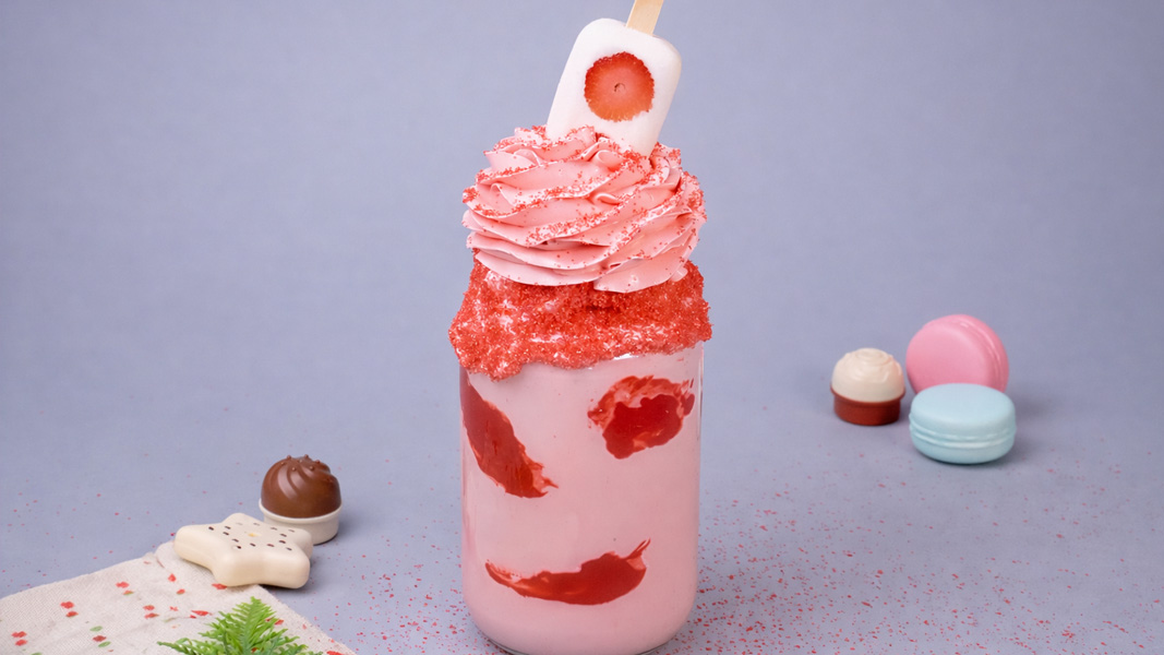 Strawberry milkshake with whipped cream and popsicle