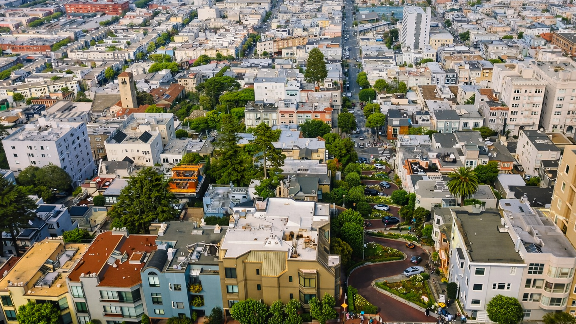 Winding street cutting through a busy city neighborhood