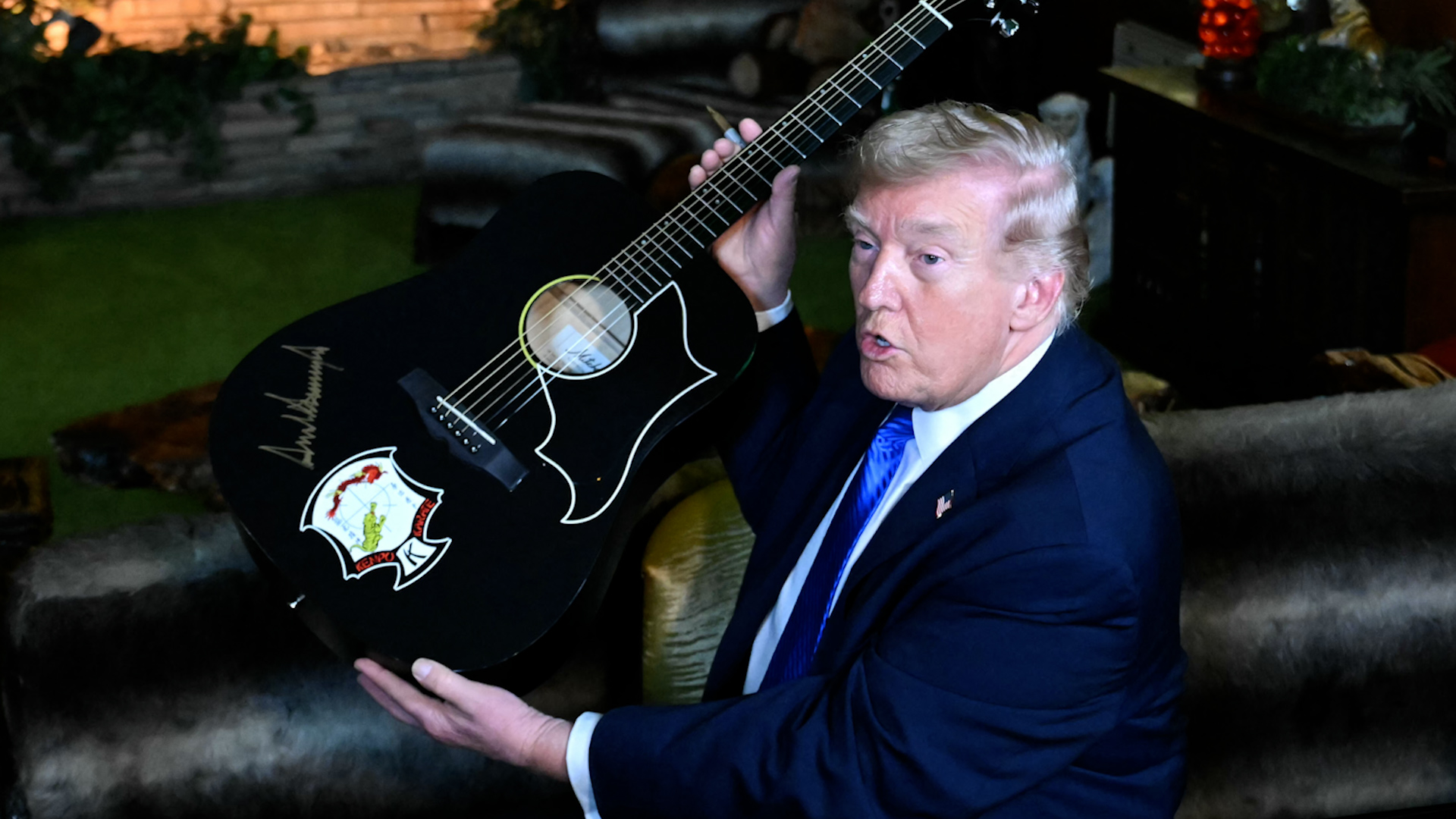 Trump signs replica Elvis guitar during Graceland visit