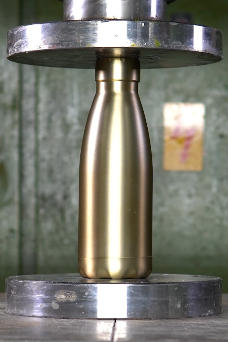 Hydraulic press crushing steel water bottle