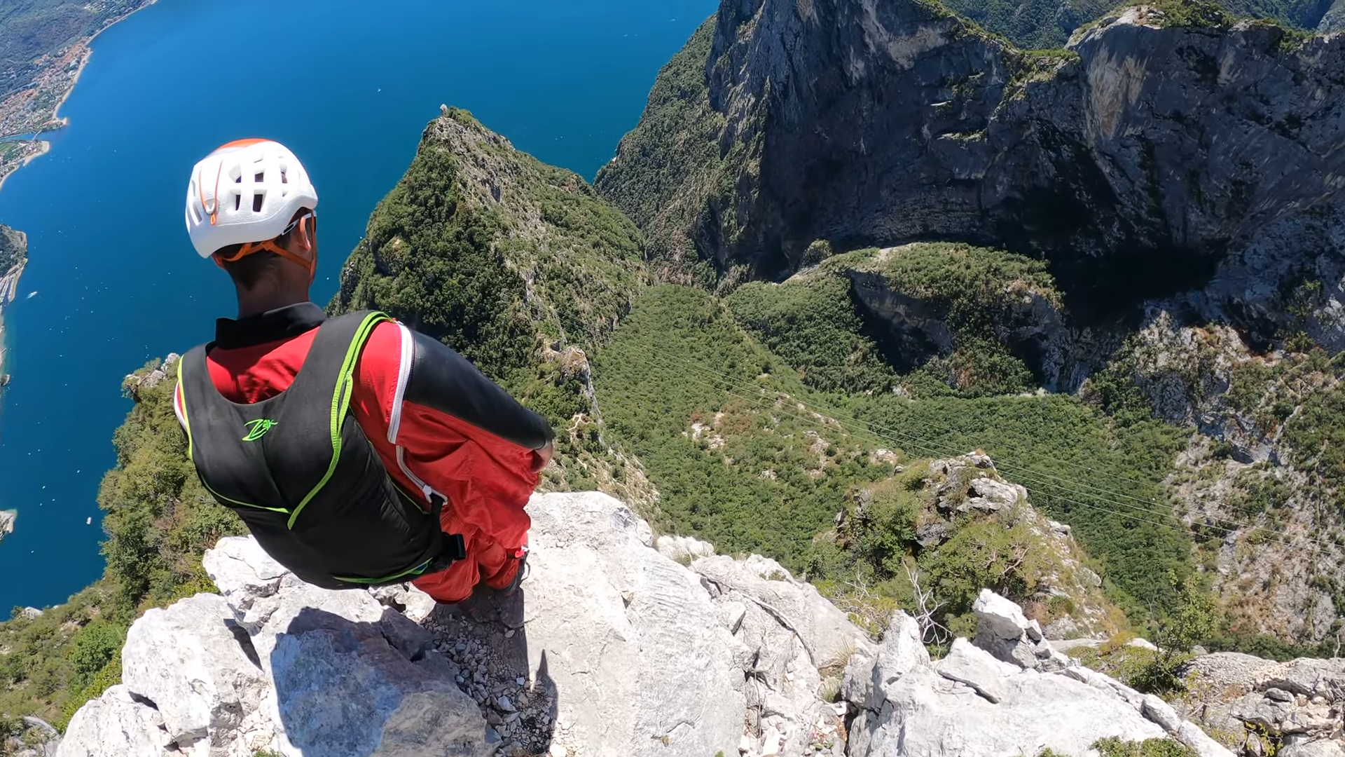 Man jumps from a cliff into a beautiful lake