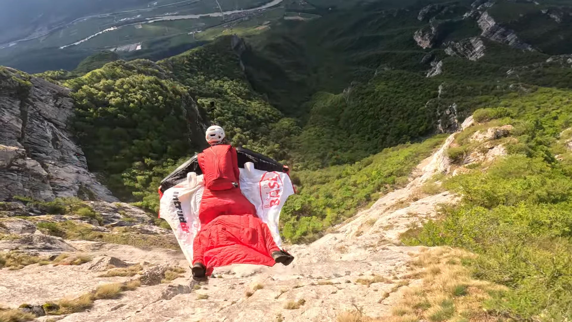 Man jumps off a cliff and flies down the valley
