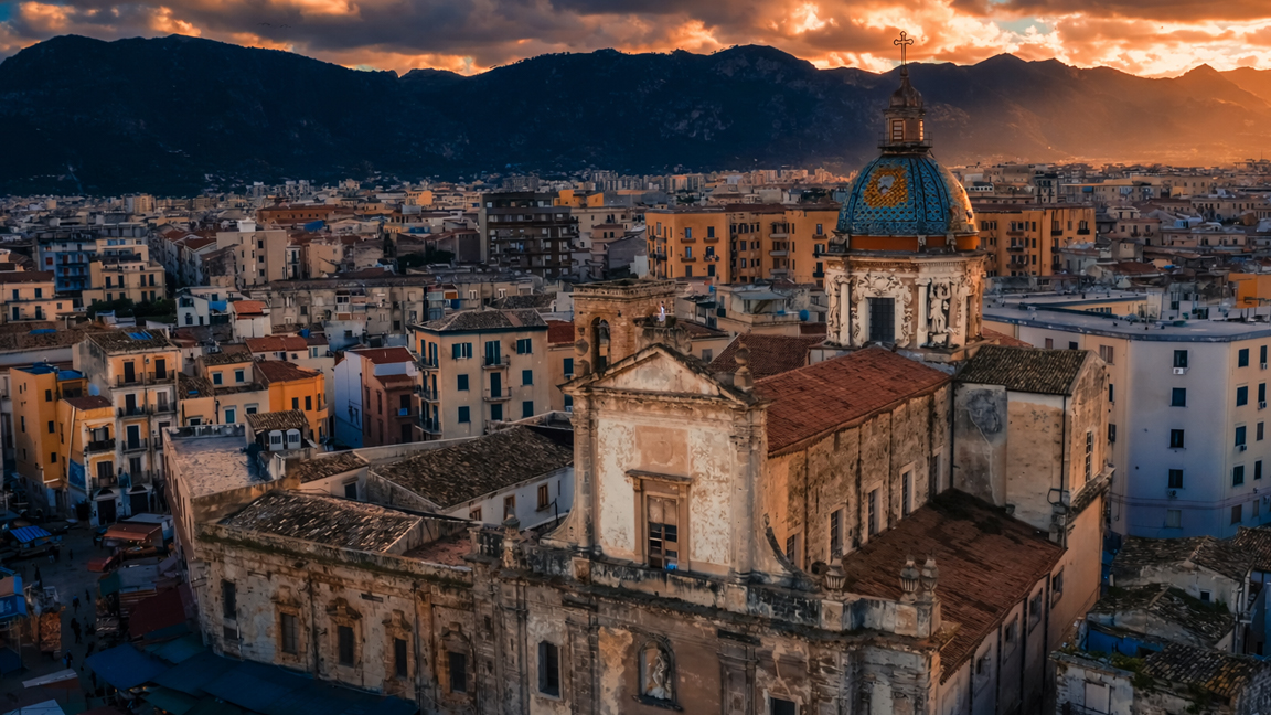 Sunset over a historic church and dense urban landscape
