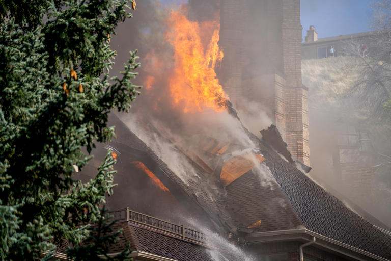 Firefighters battle house fire in Sandy, smoke and flames visible